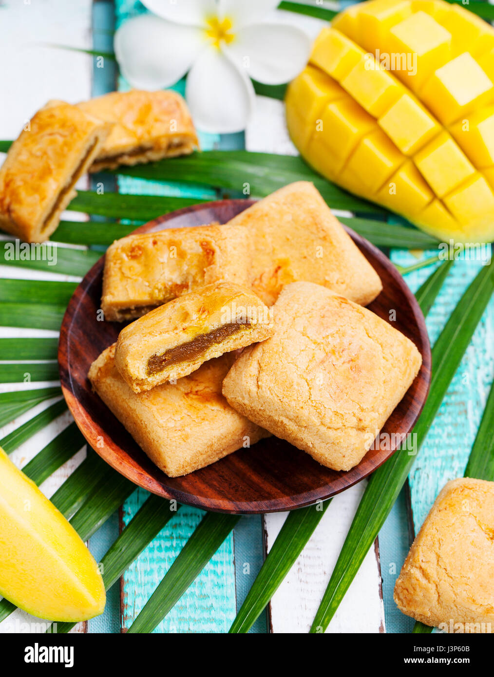 Mango cookies in wooden bowl on colorful wooden background with palm ...