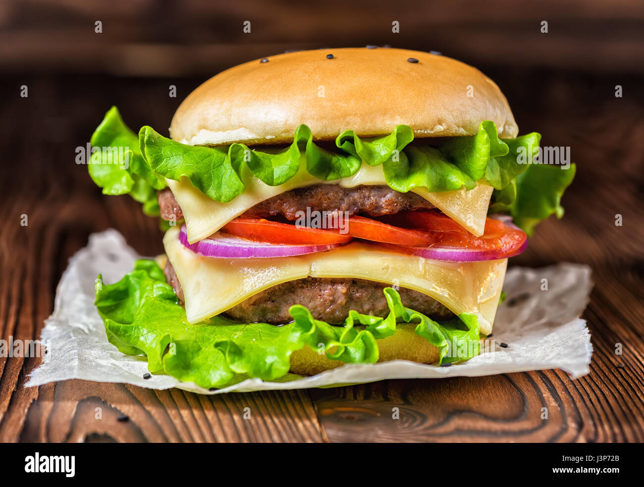 homemade full cheeseburger with vegetables, spices and beef meat on ...