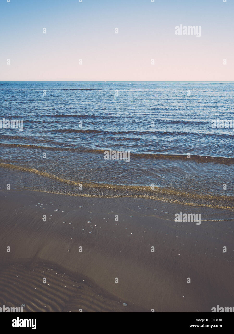 frozen sea beach with blue sky and snow covered tracks - retro vintage ...