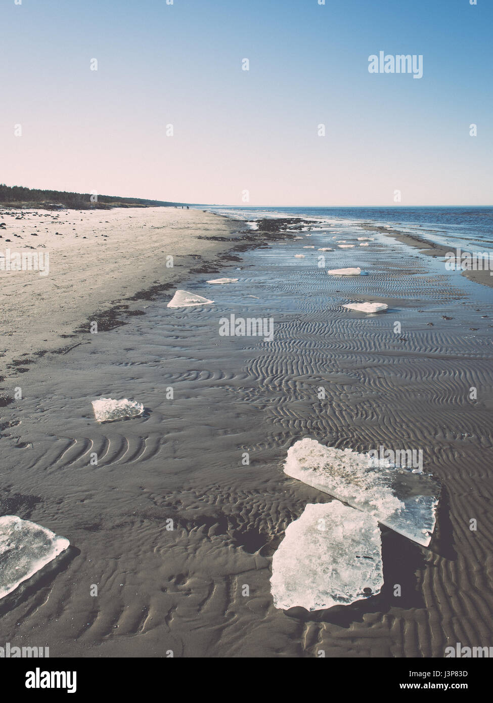 frozen sea beach with blue sky and snow covered tracks - retro vintage ...