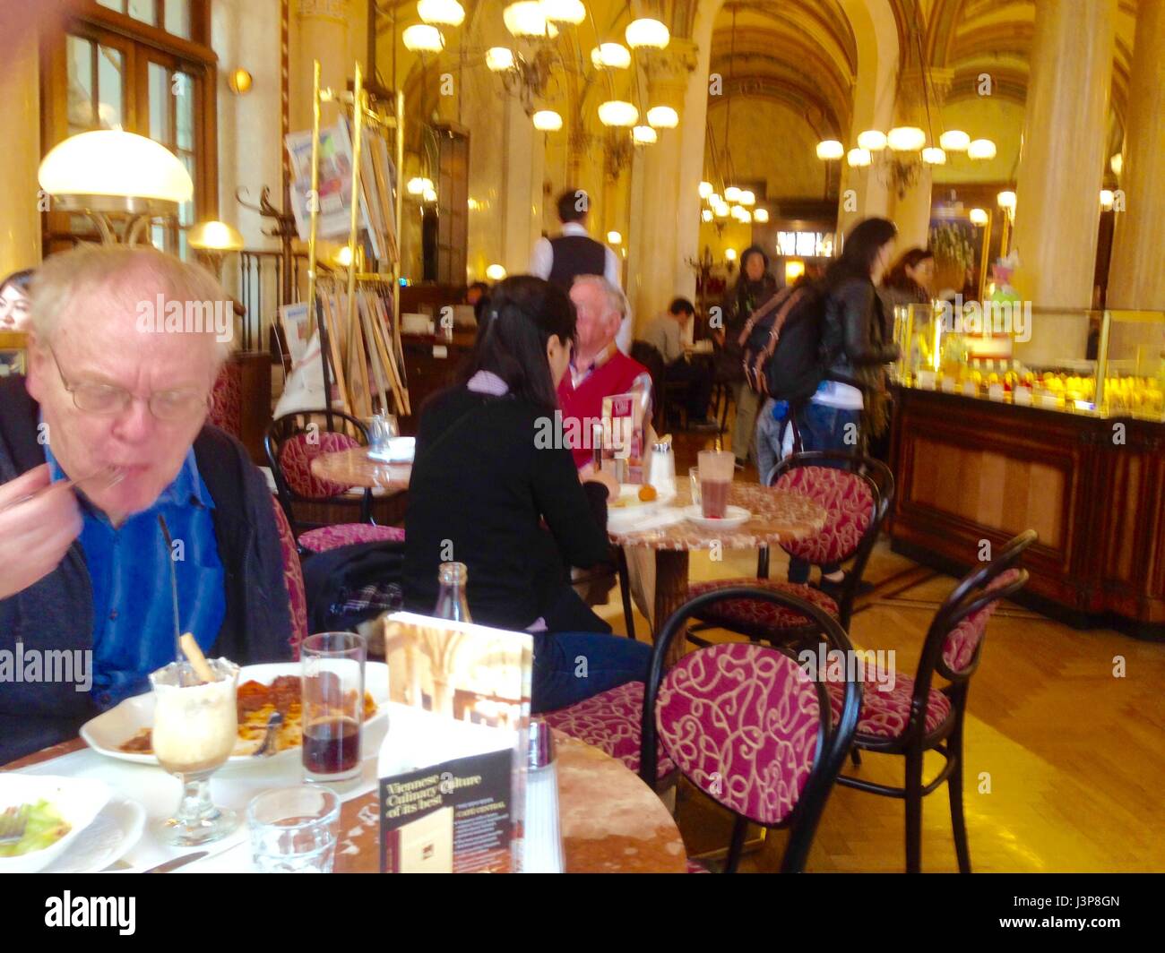 Vienna, Austria, Man Eating at Table, inside Cafe Bar Central, busy ...