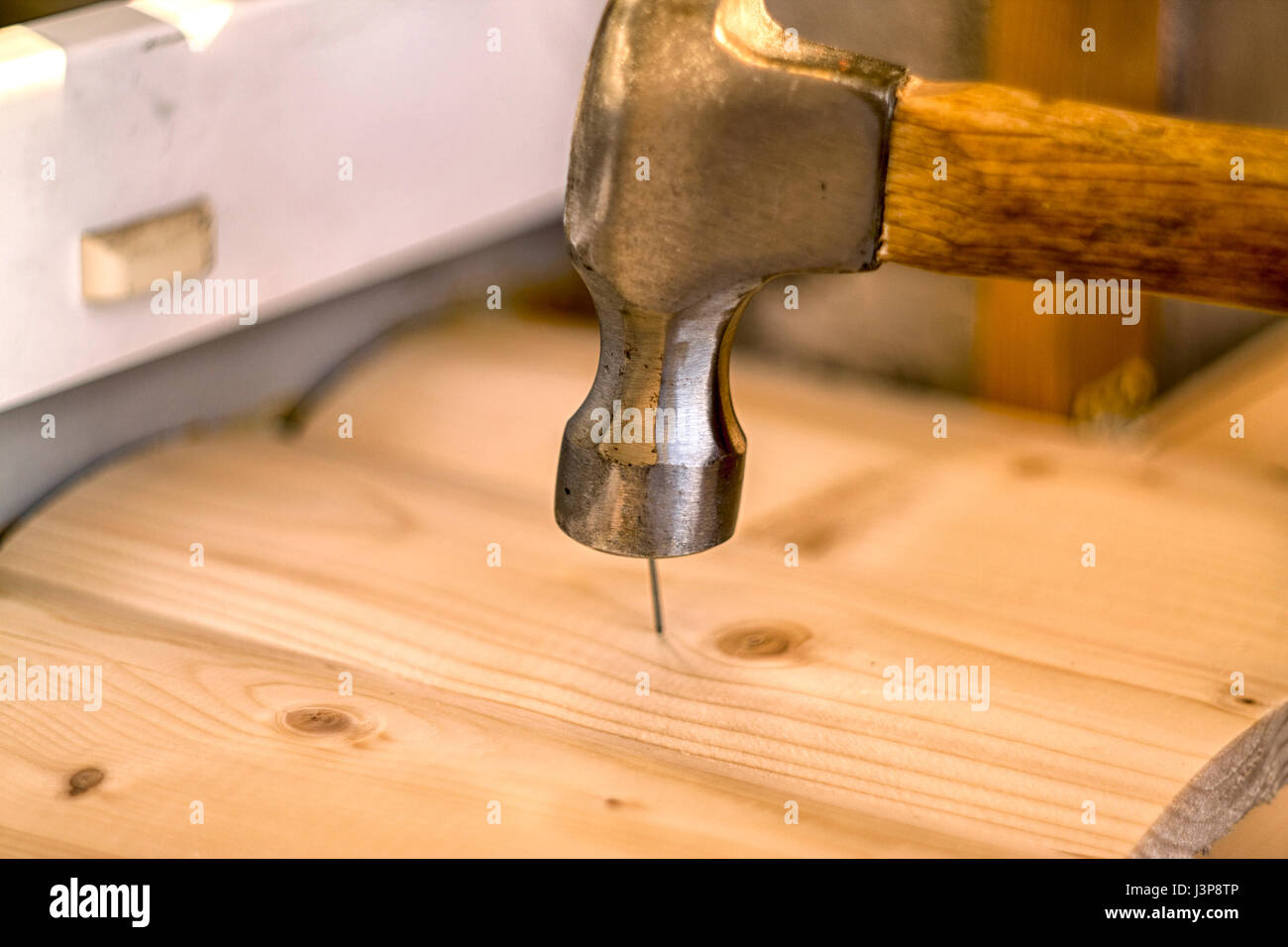 Hammer clogs a nail into a wooden board Stock Photo - Alamy