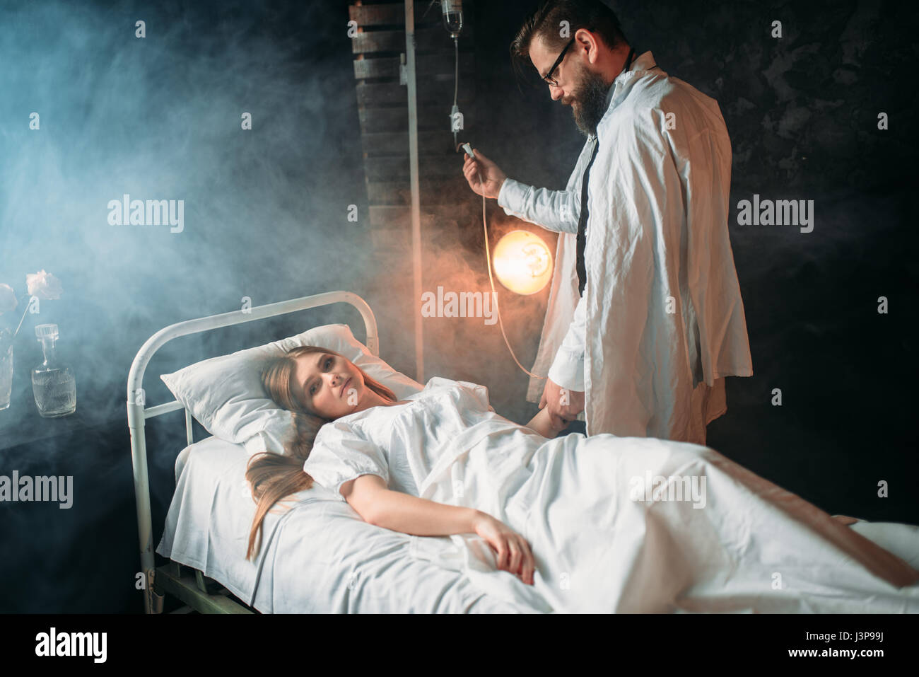 Man adjusts the drip of young sick woman in the hospital. Illness of ...