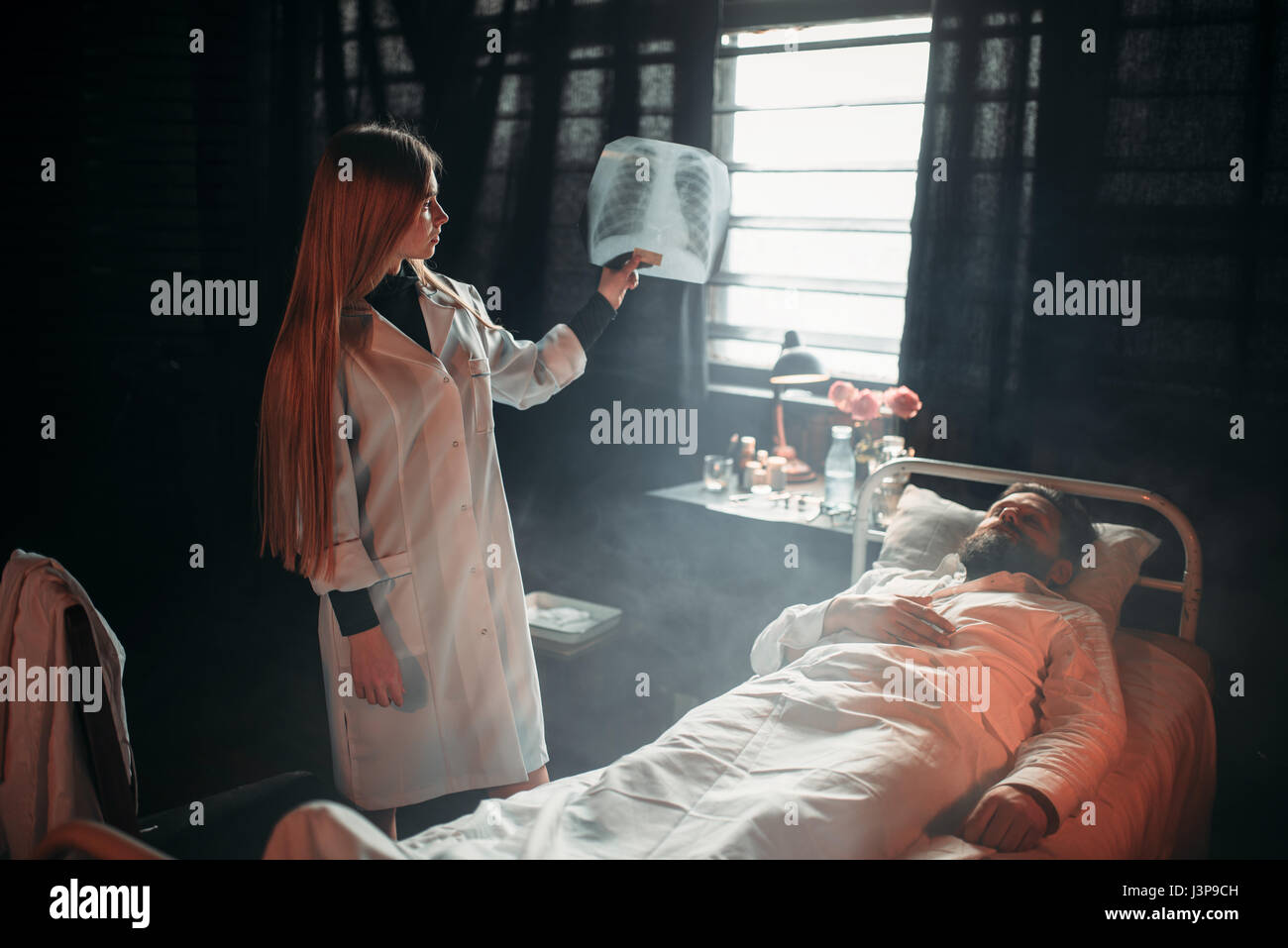 Female doctor looking at x-ray picture of sick man in hospital ...