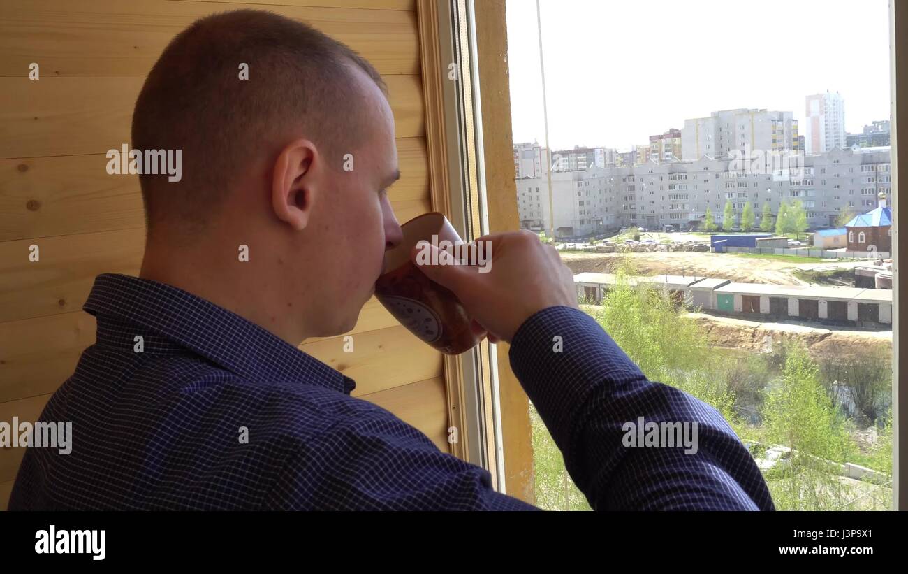 Sad, depressed man drinking tea by the window in home Stock Photo - Alamy