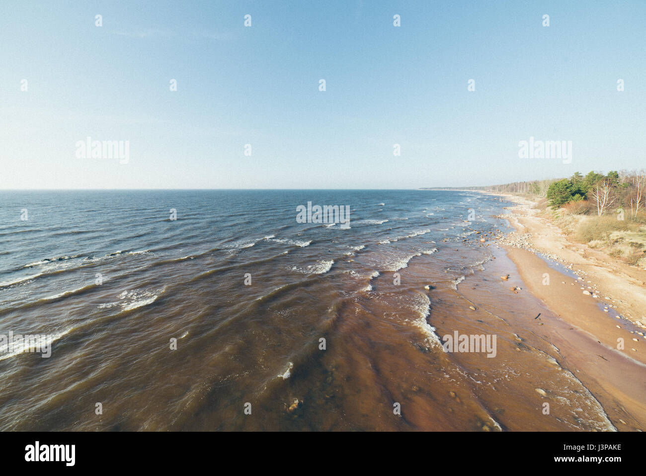 Shoreline of Baltic sea beach with rocks and sand dunes under clouds ...