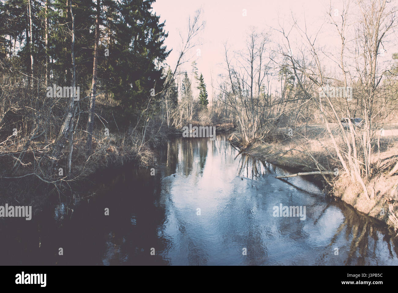 scenic spring colored river in country with trees and reflections ...