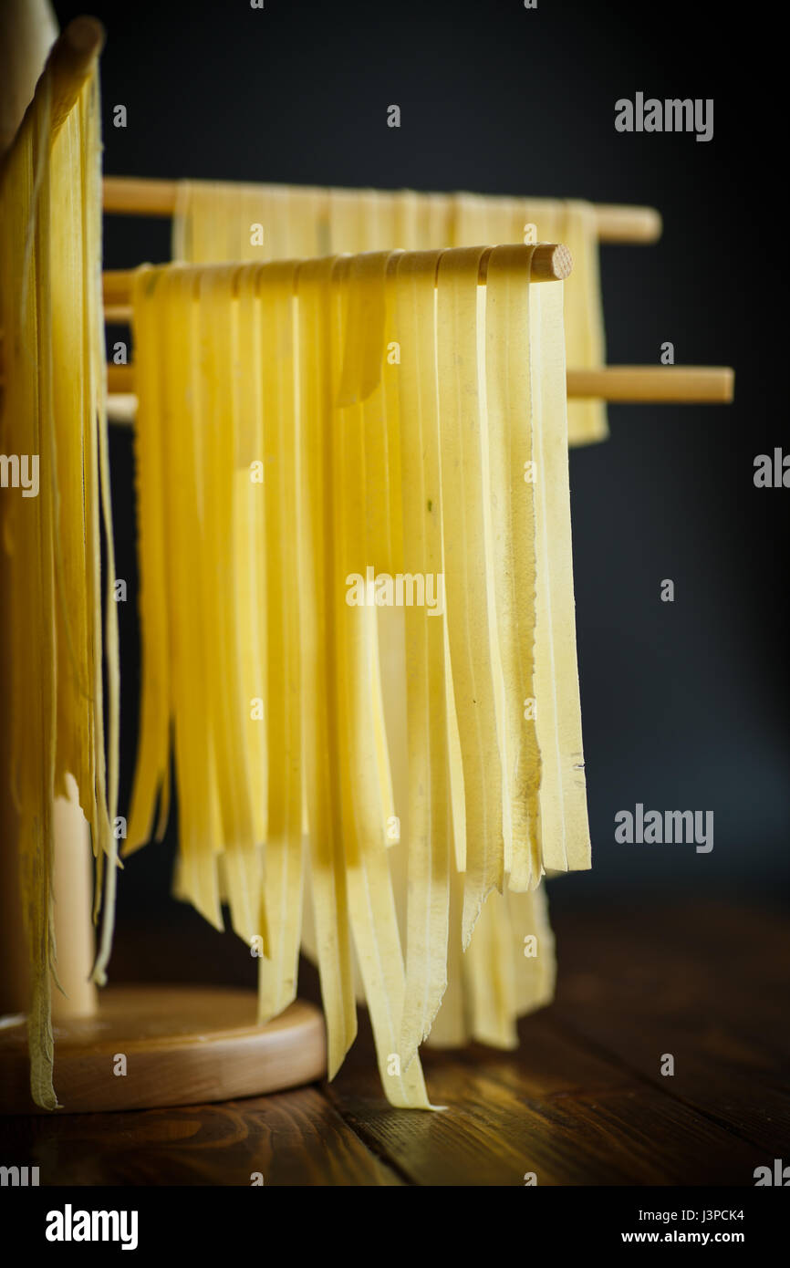 Home-made noodles are dried on a wooden stand Stock Photo - Alamy