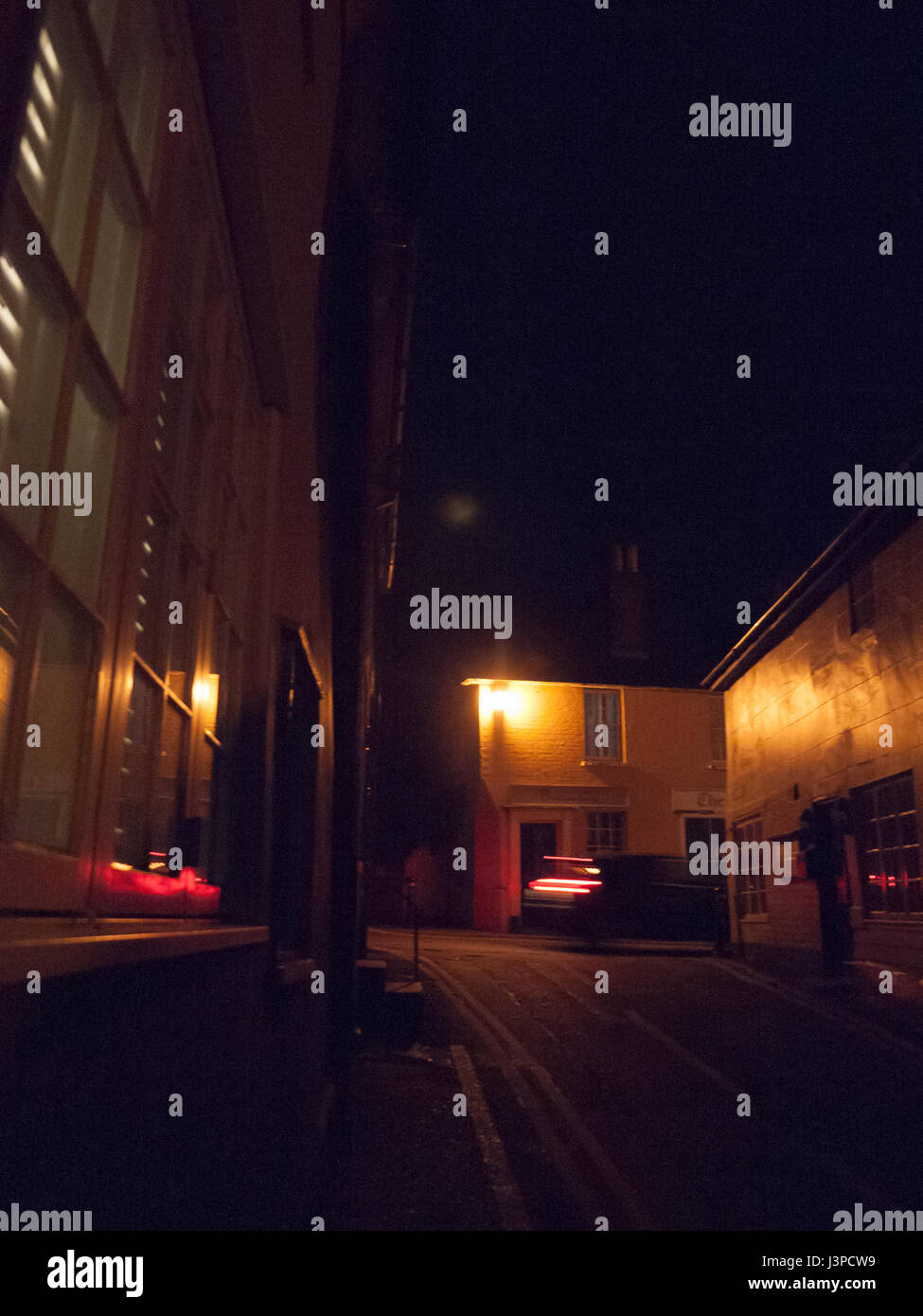 street light outside in the dark at night with a car moving blurred ...