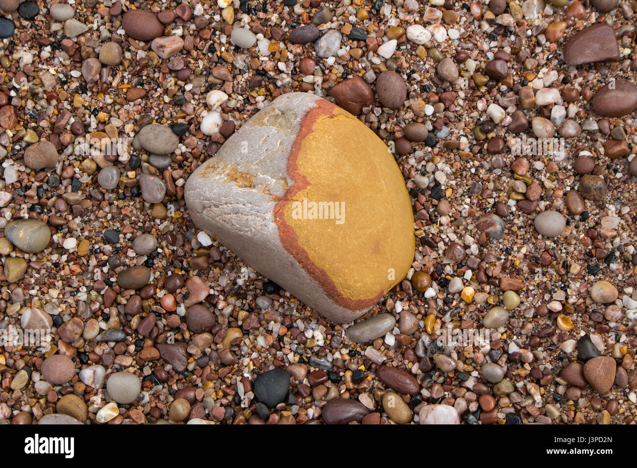Rock art - colourful natural rocks on a beach Stock Photo - Alamy