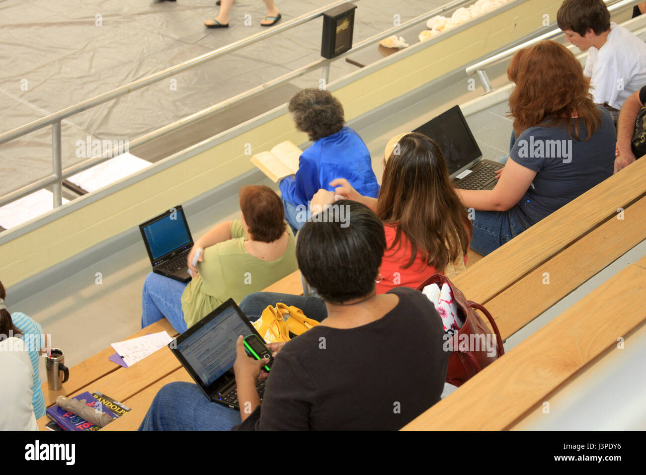 Parents using personal computers while waiting for their children at ...