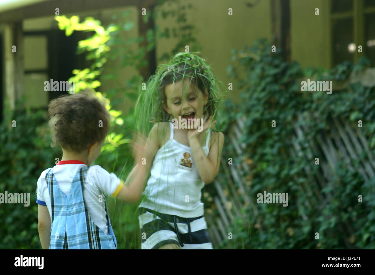 Two little kids playing in the yard Stock Photo - Alamy