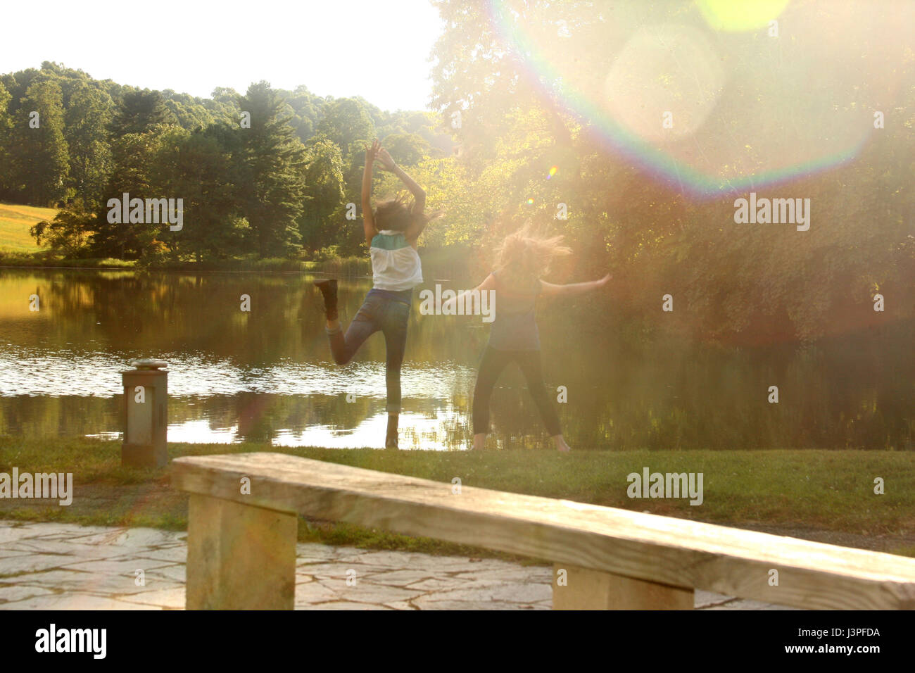 Two girls jumping into the lake hi-res stock photography and images - Alamy