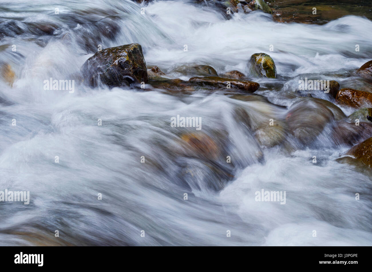 Rushing flowing water over rocks in river Stock Photo - Alamy