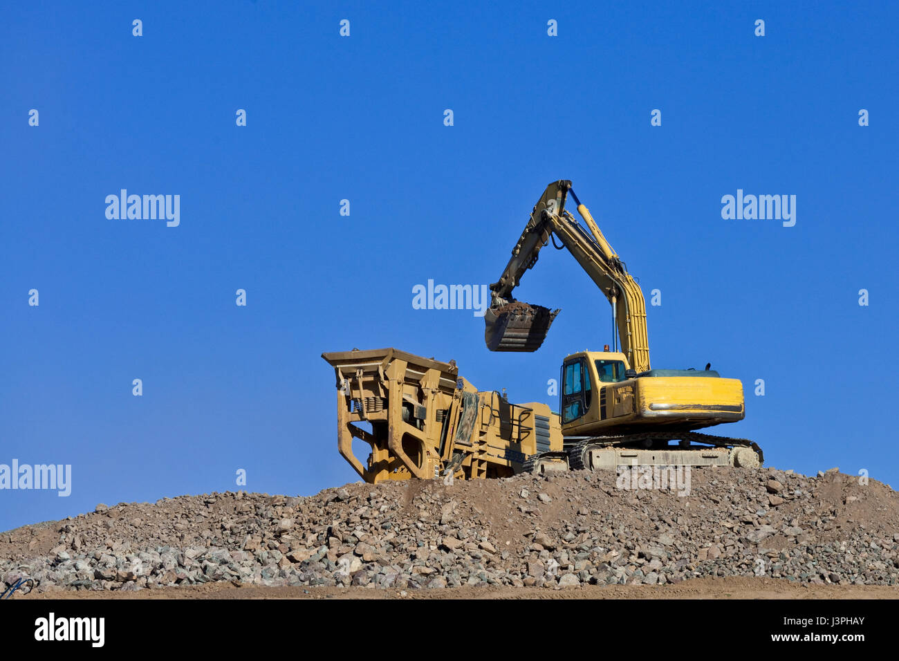 Earth moving equipment loading soil into waiting container Stock Photo ...
