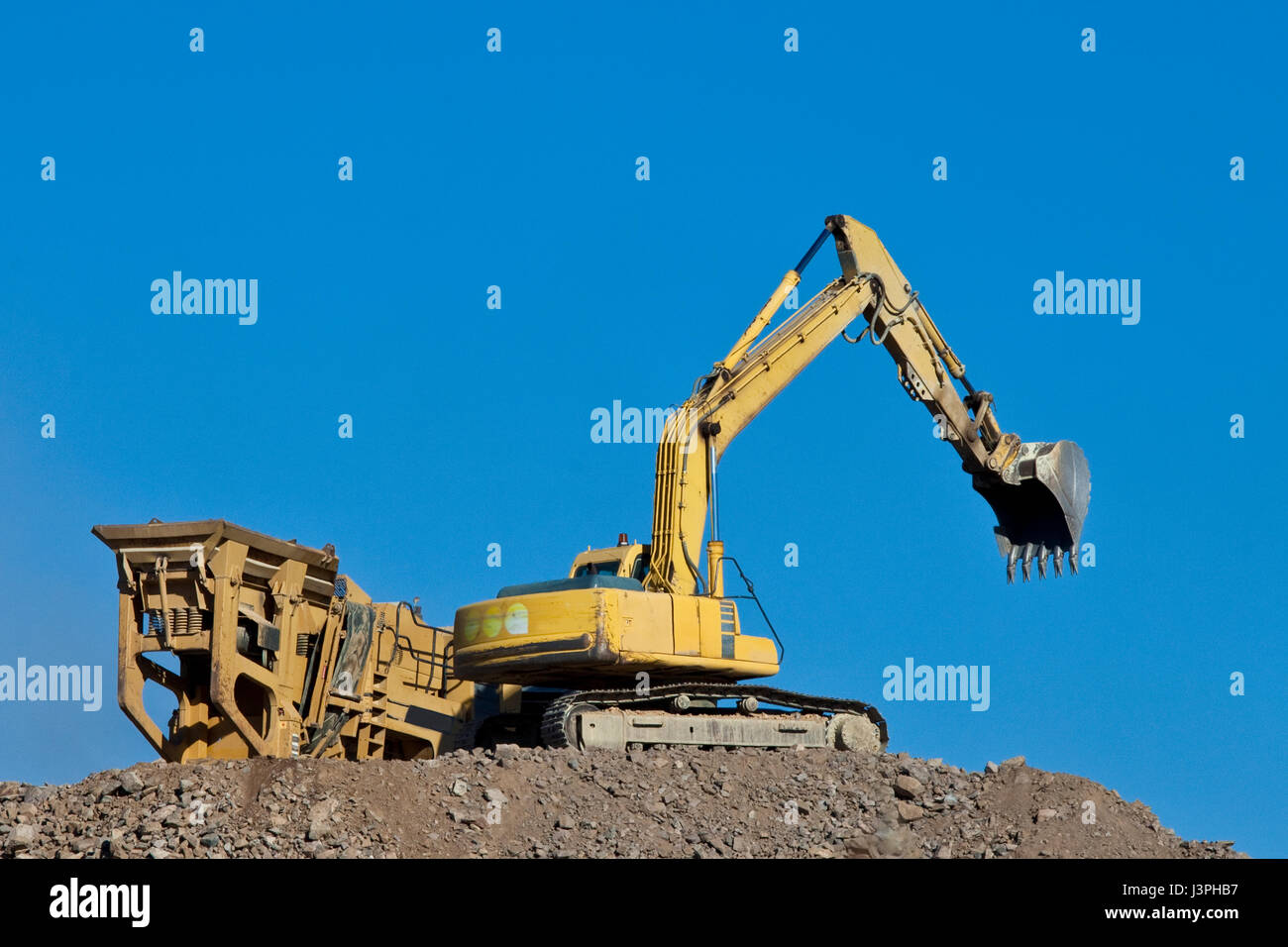 Earth moving equipment loading soil into waiting container Stock Photo ...