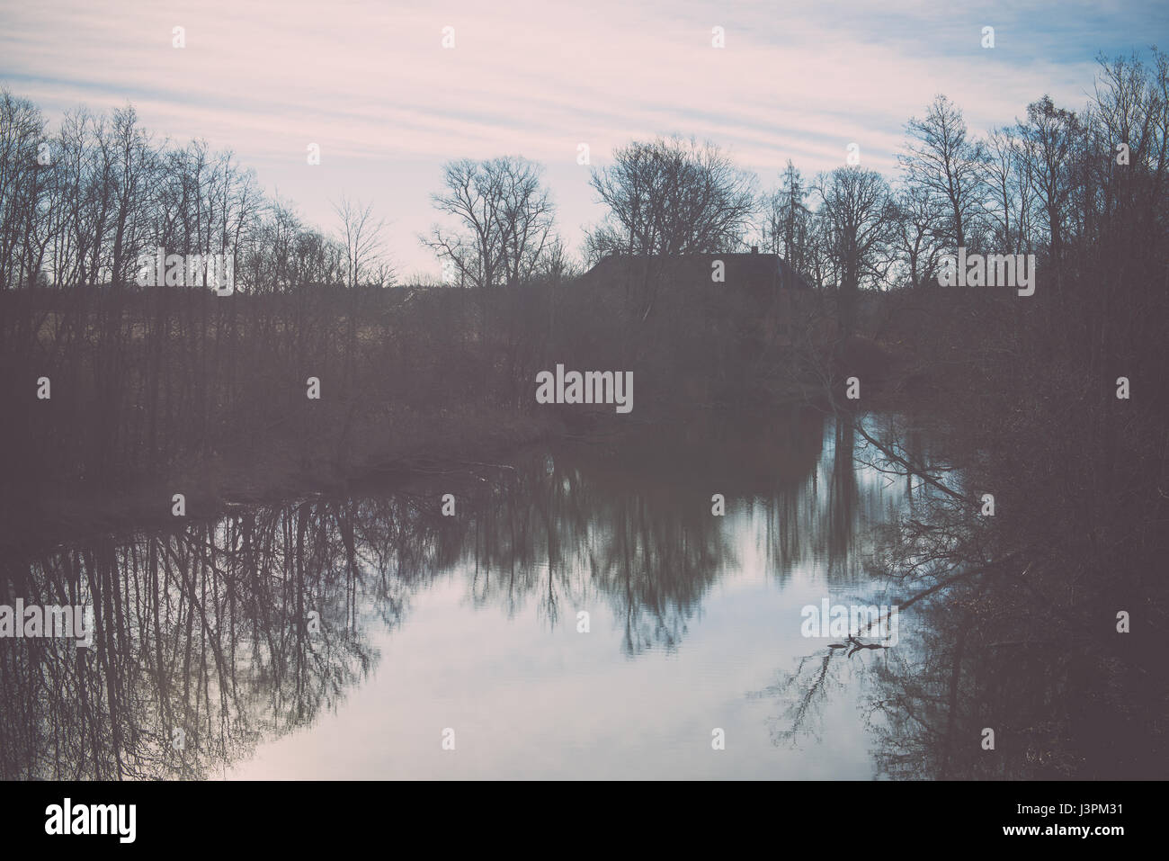 dramatic clouds over the river in misty morning in spring with ...