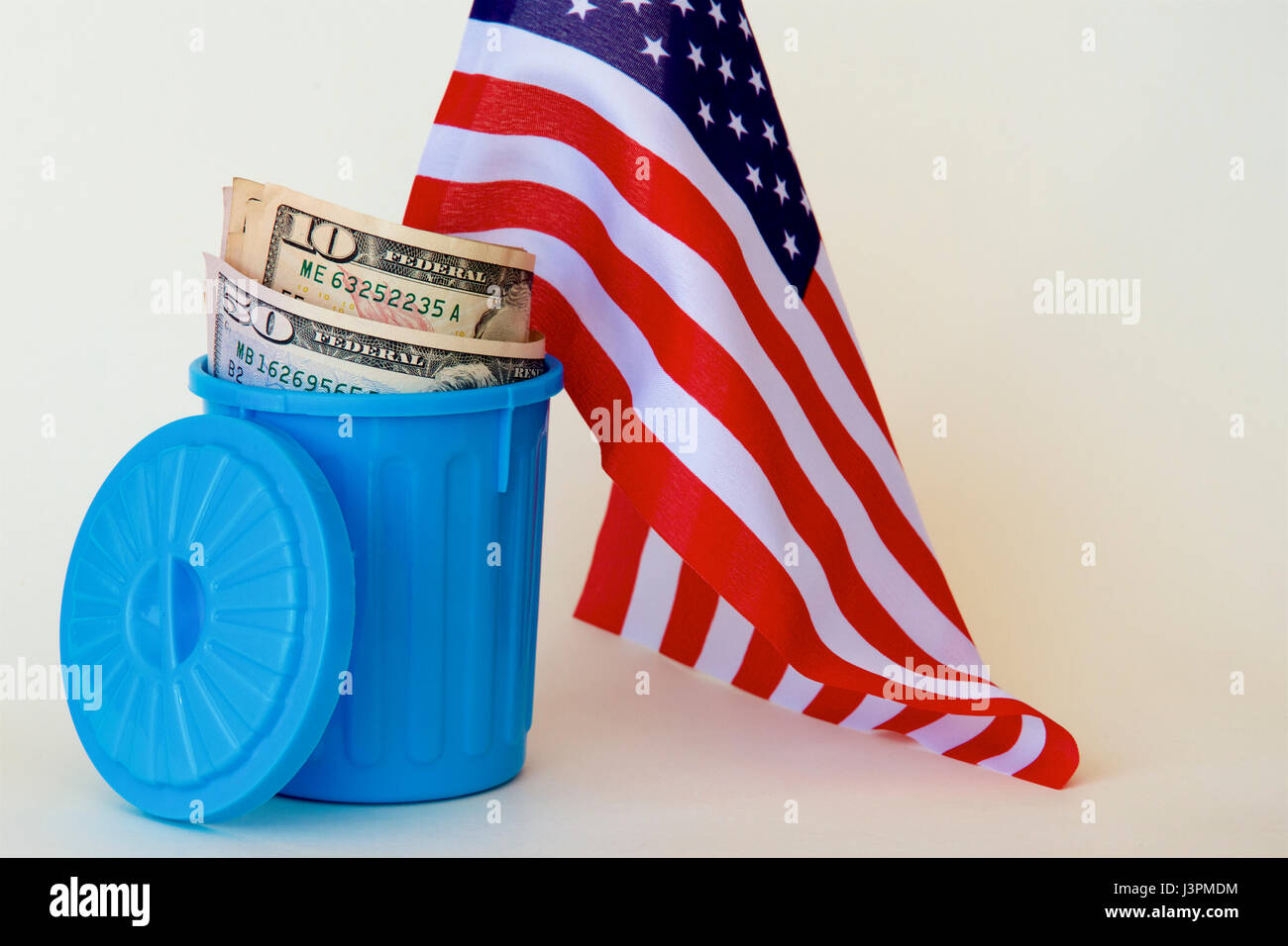 American money in a garbage bin with the flag Stock Photo - Alamy