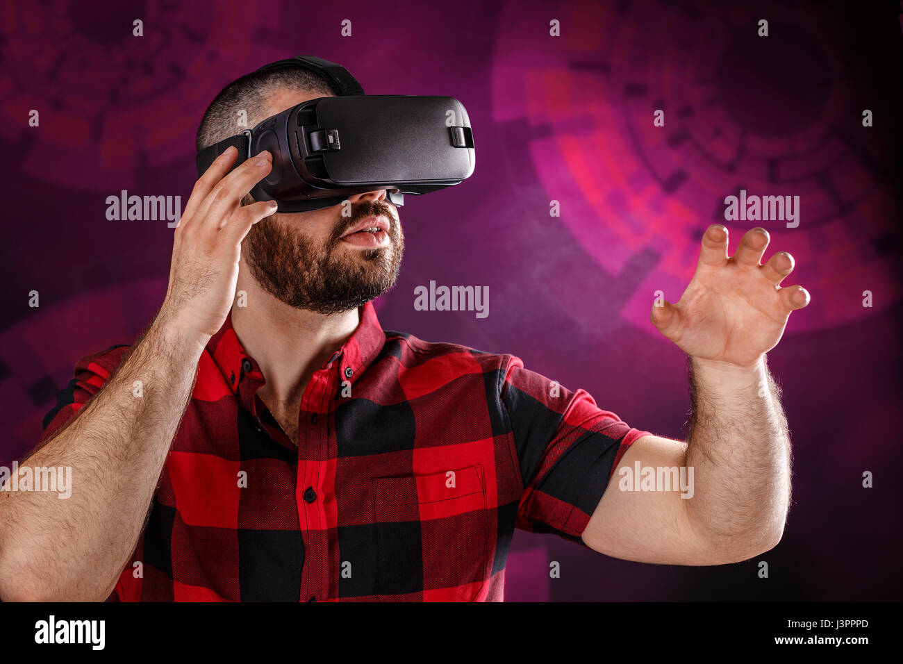 Young man using VR glasses headset trying to touch objects in virtual ...