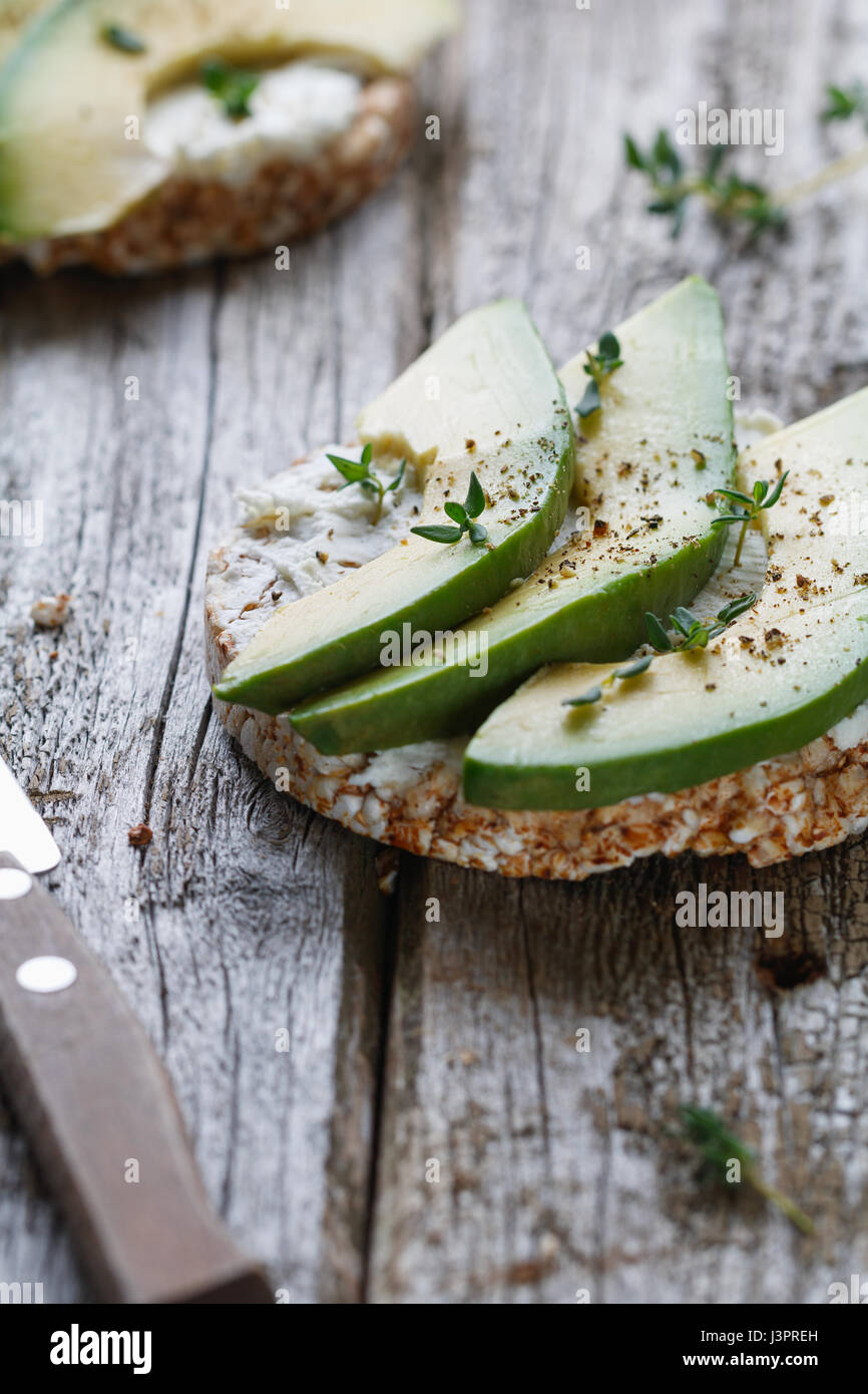 Close up of a toast of grain bread with soft white cheese and chopped ...