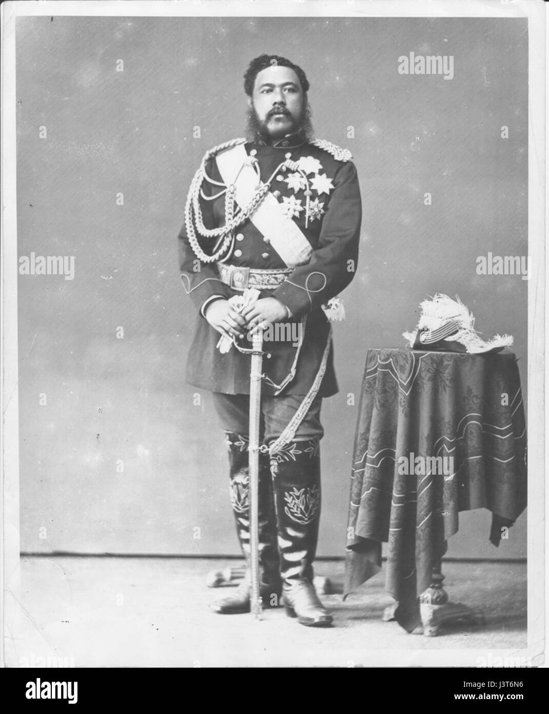 This photograph captures King Kalākaua of Hawaii standing with a saber ...