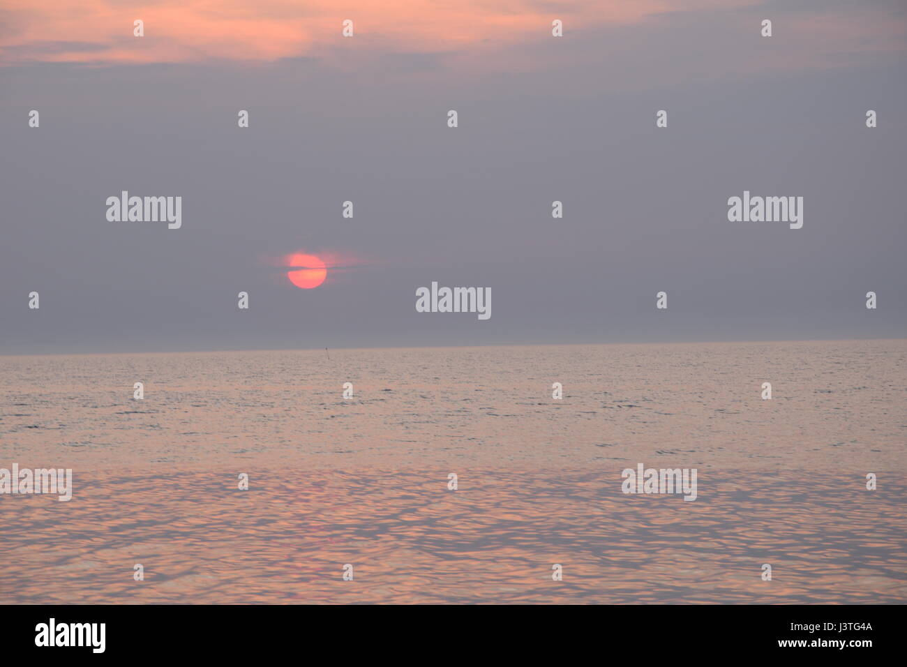 Red sun setting on sea hi-res stock photography and images - Alamy