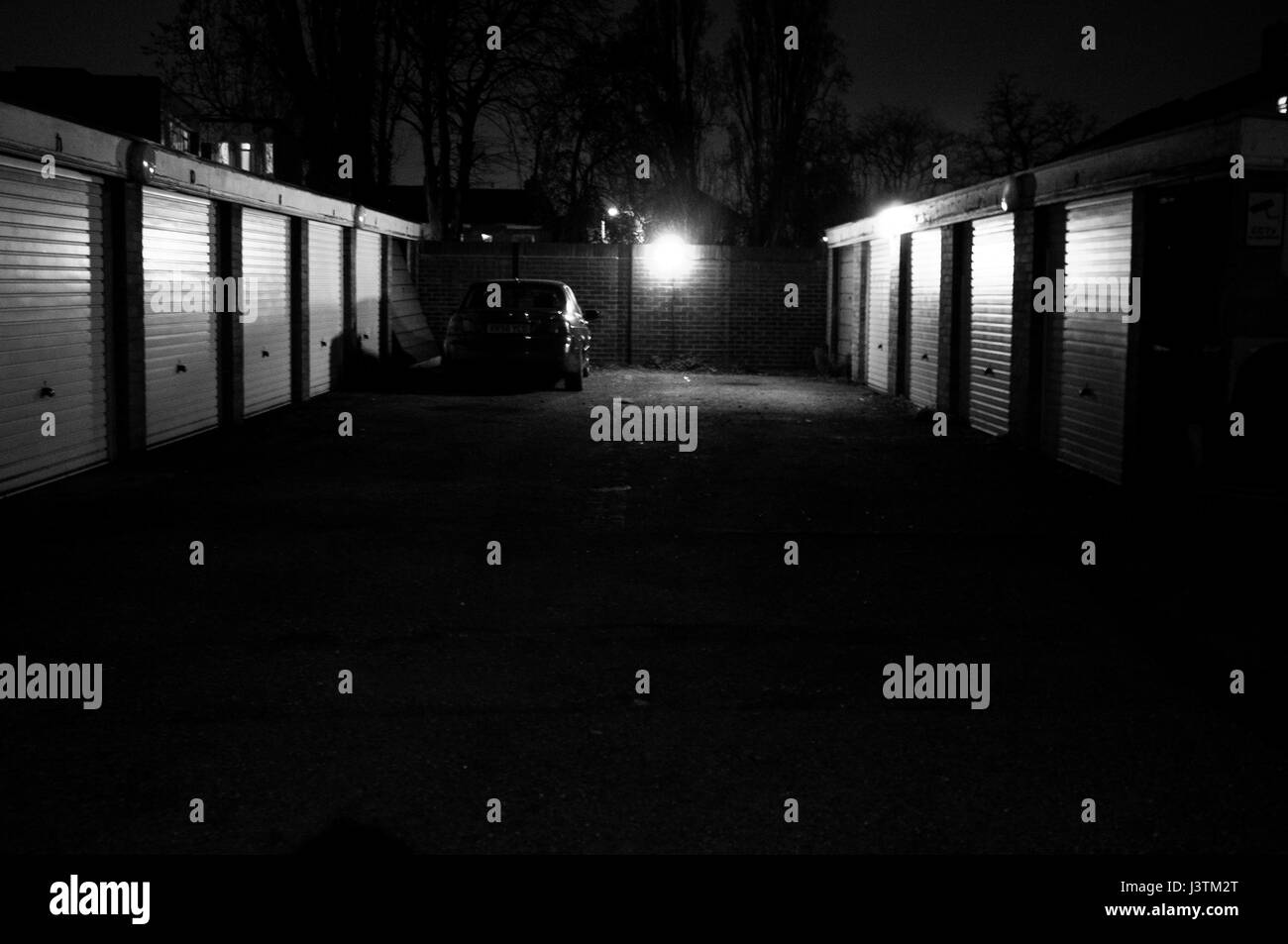 View of rows of garages at night Stock Photo - Alamy