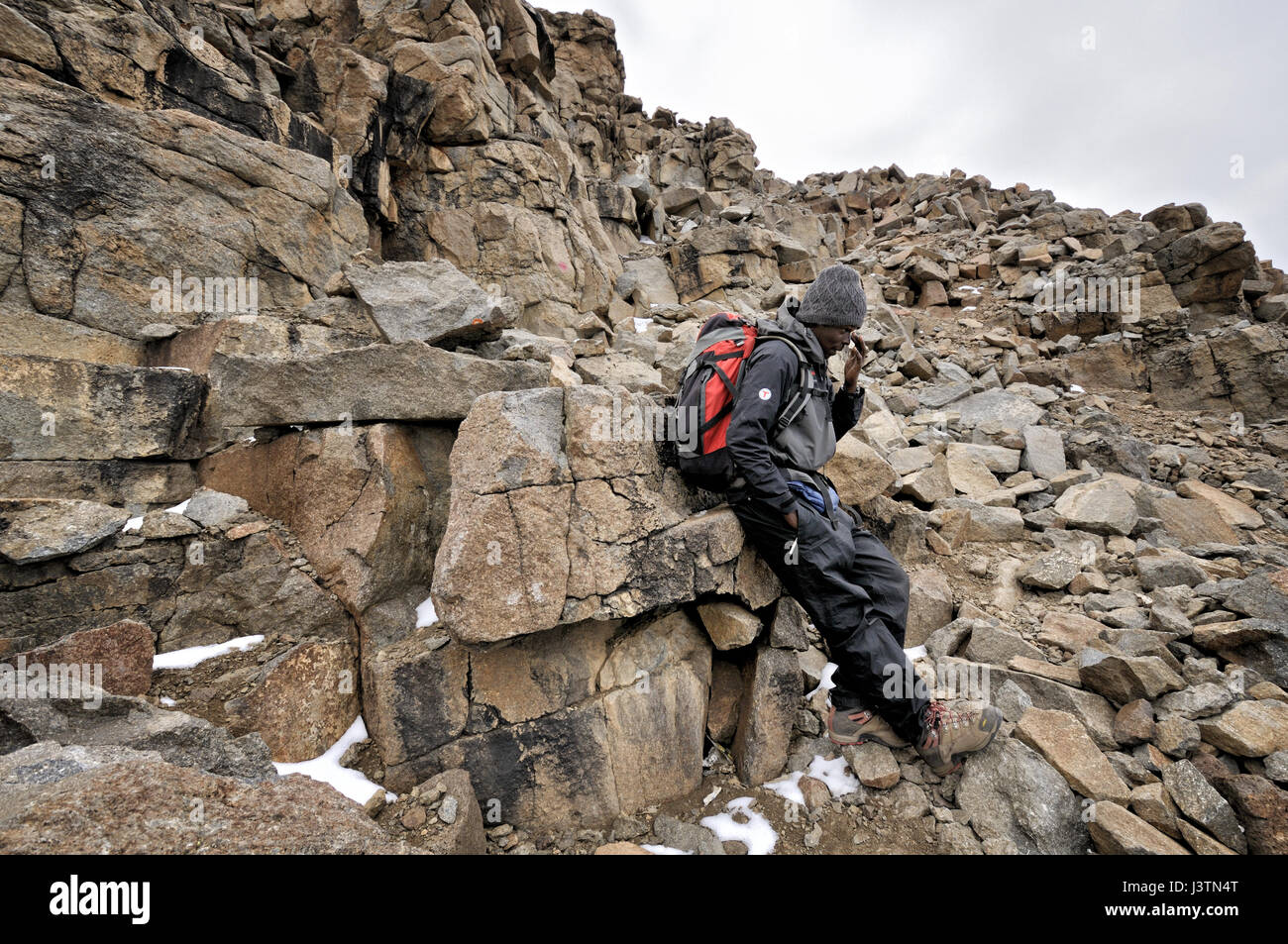 Mountain guide take a break on the Western Breach, Mount Kilimanjaro ...