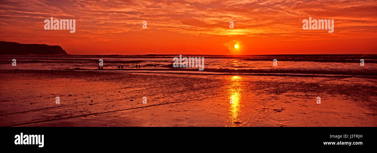 A colourful fiery panoramic sunset from the beach at Borth in Mid Wales ...