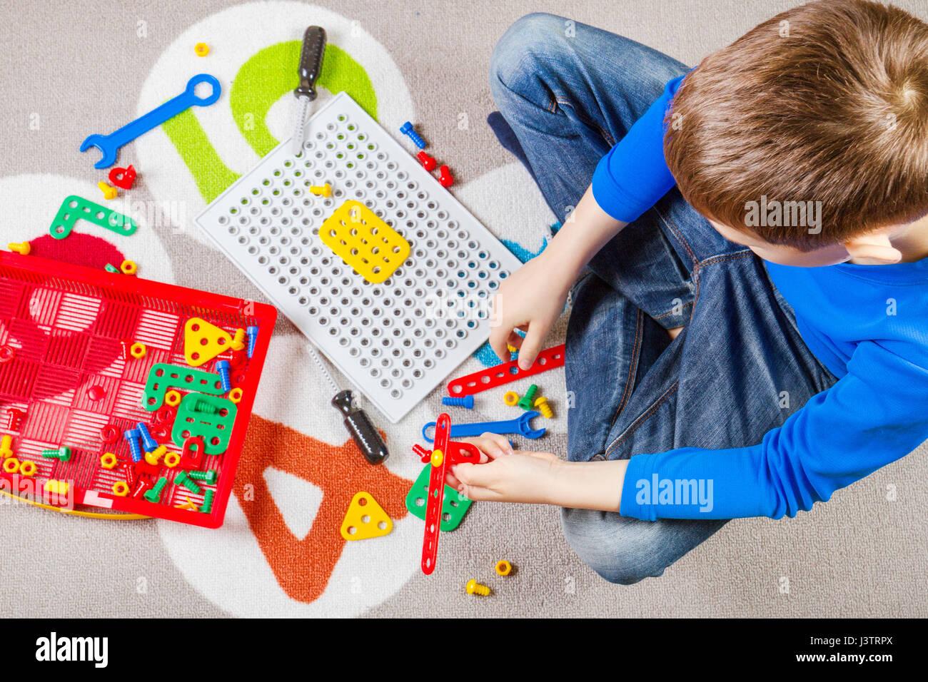Child playing with toys tool kit. Top view Stock Photo - Alamy