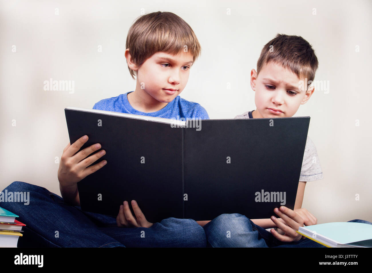 Two little boys reading books at home Stock Photo - Alamy