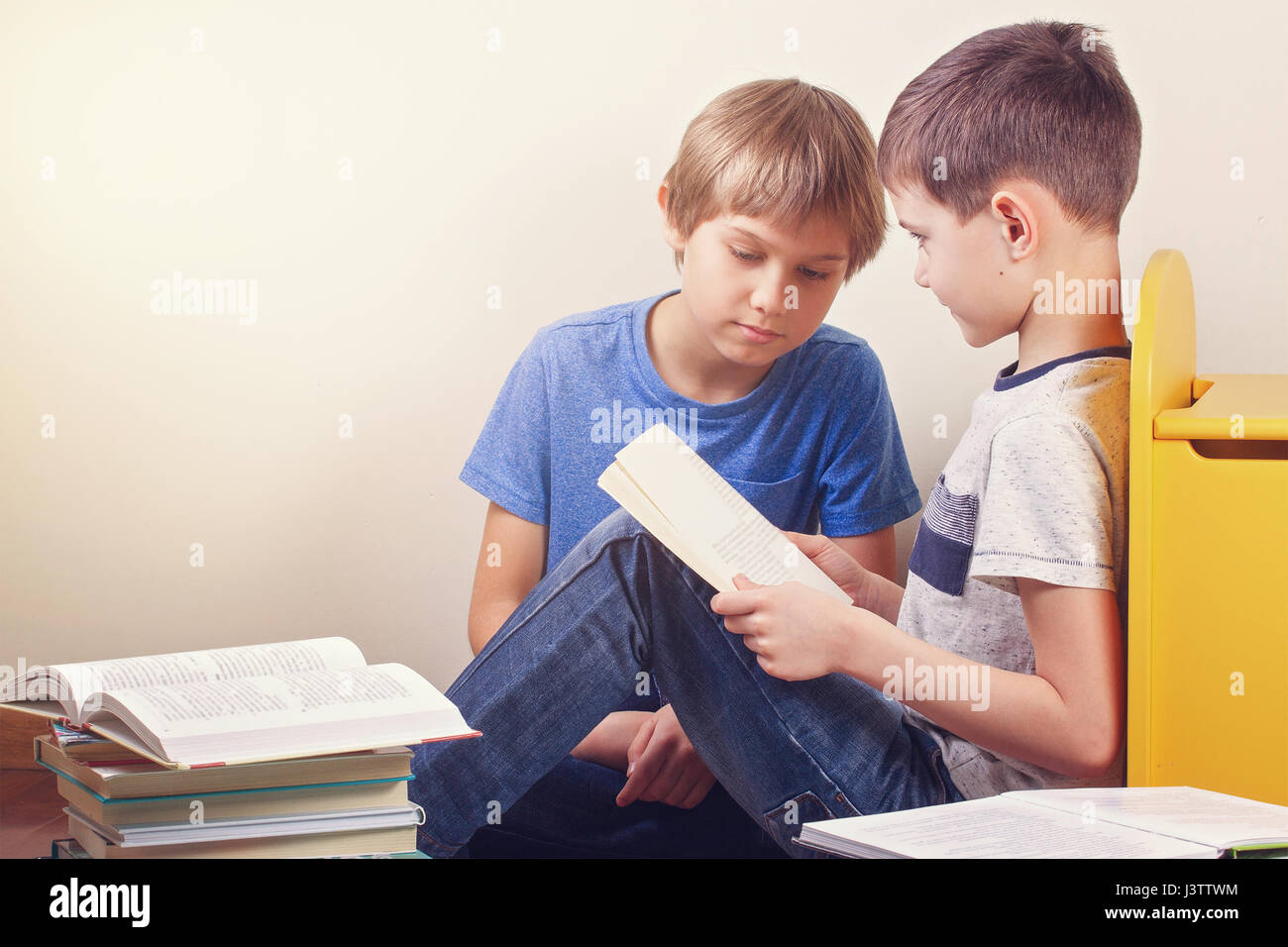 Kids sitting and reading books at home Stock Photo - Alamy