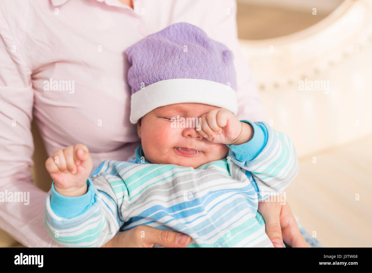 Portrait of newborn tired baby boy rubbing eyes Stock Photo - Alamy