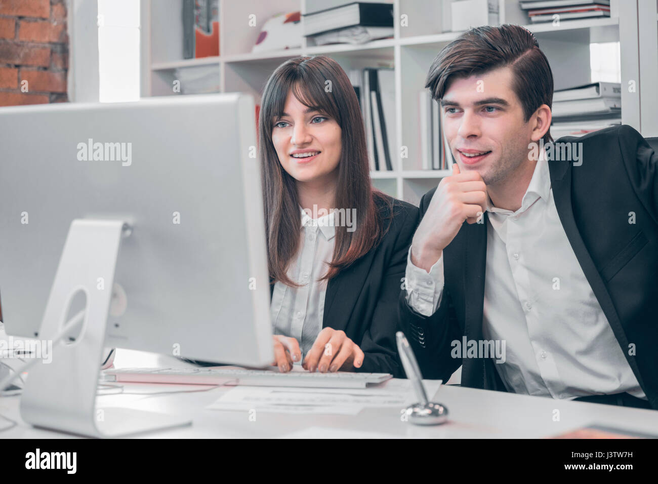 Two business people at monitor of desktop computer in office Stock ...