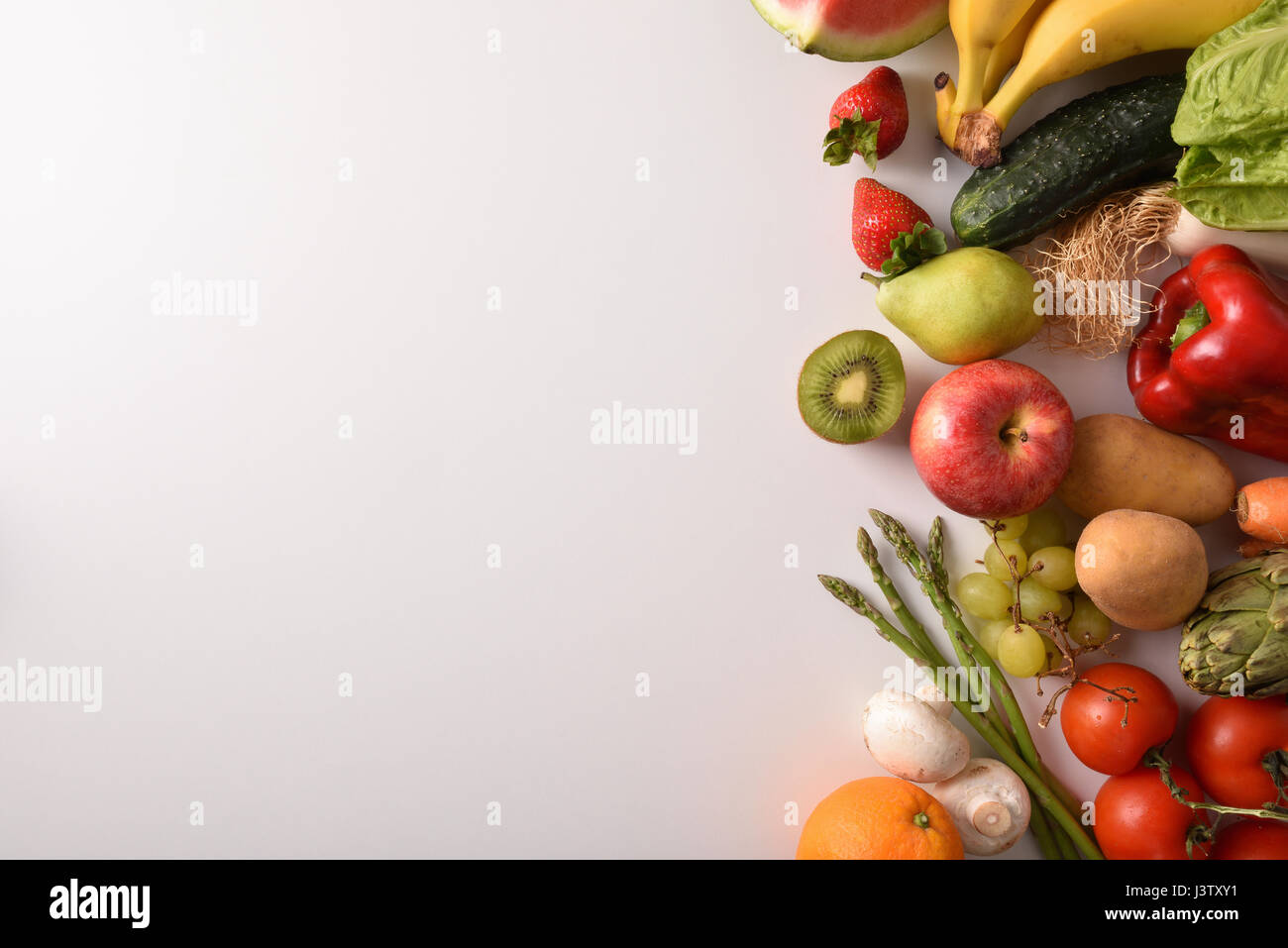 Assortment of fruits and vegetables on a white table. Horizontal ...