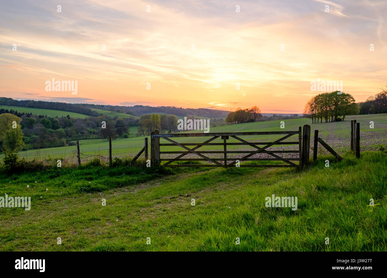 Countryside sunset over field gate Stock Photo - Alamy