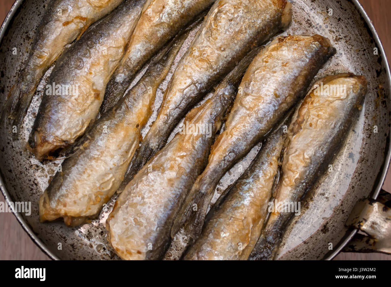Fried fish herring, Fried fish in a frying pan Stock Photo - Alamy