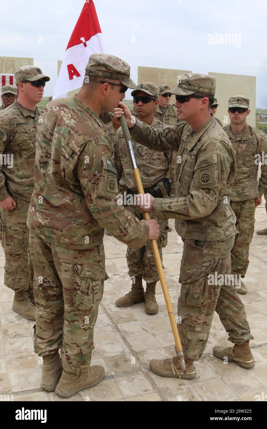 U.S. Army Capt. Ryan Burch, outgoing commander, passes the guidon to ...