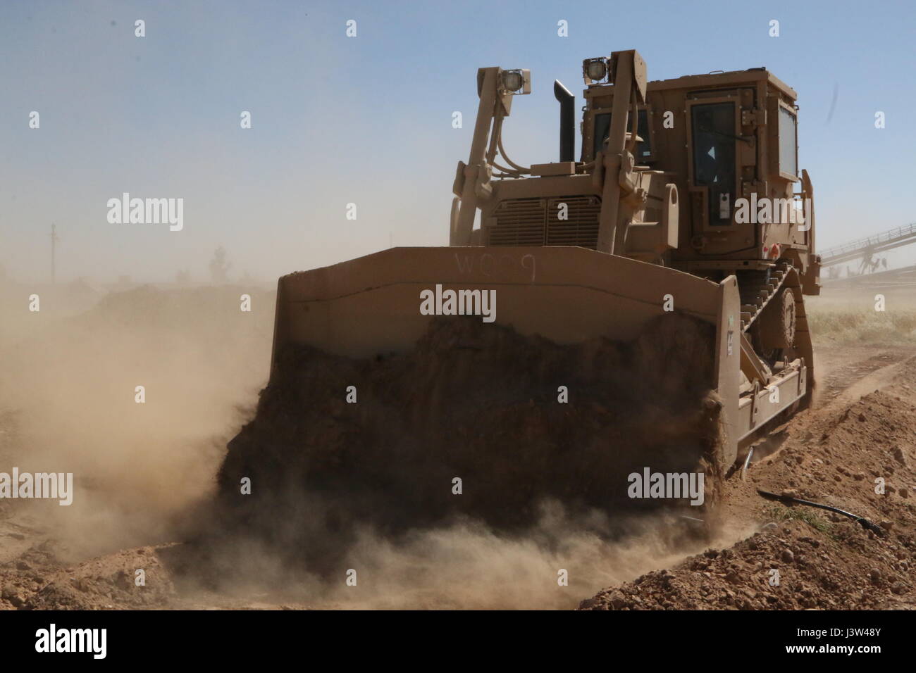 An Iraqi federal police member drives a bulldozer during a training ...