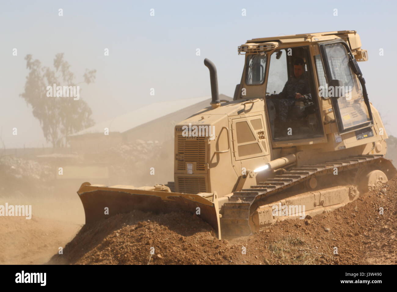 An Iraqi federal police member drives a bulldozer during a training ...