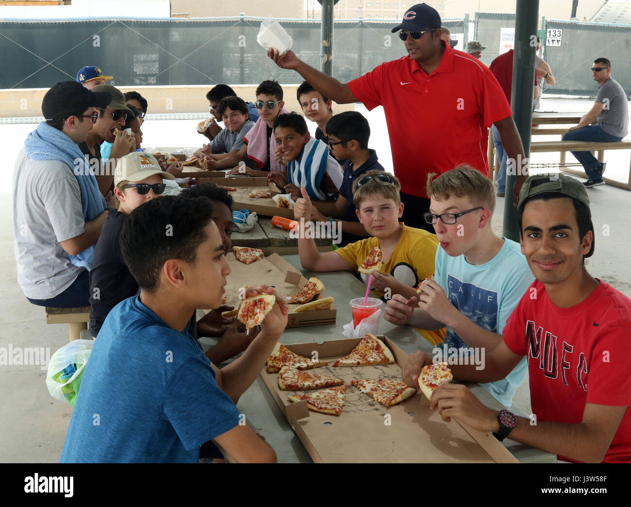 Boy Scouts of Troop 965 Kuwait eat pizza before the start of the swim ...