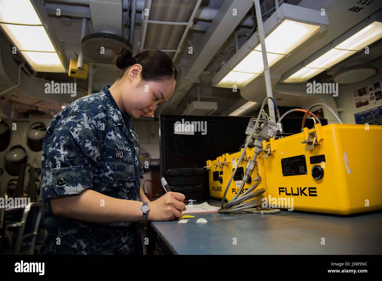 An Aviation Boatswain's Mate calibrates a pressure switch in the ...
