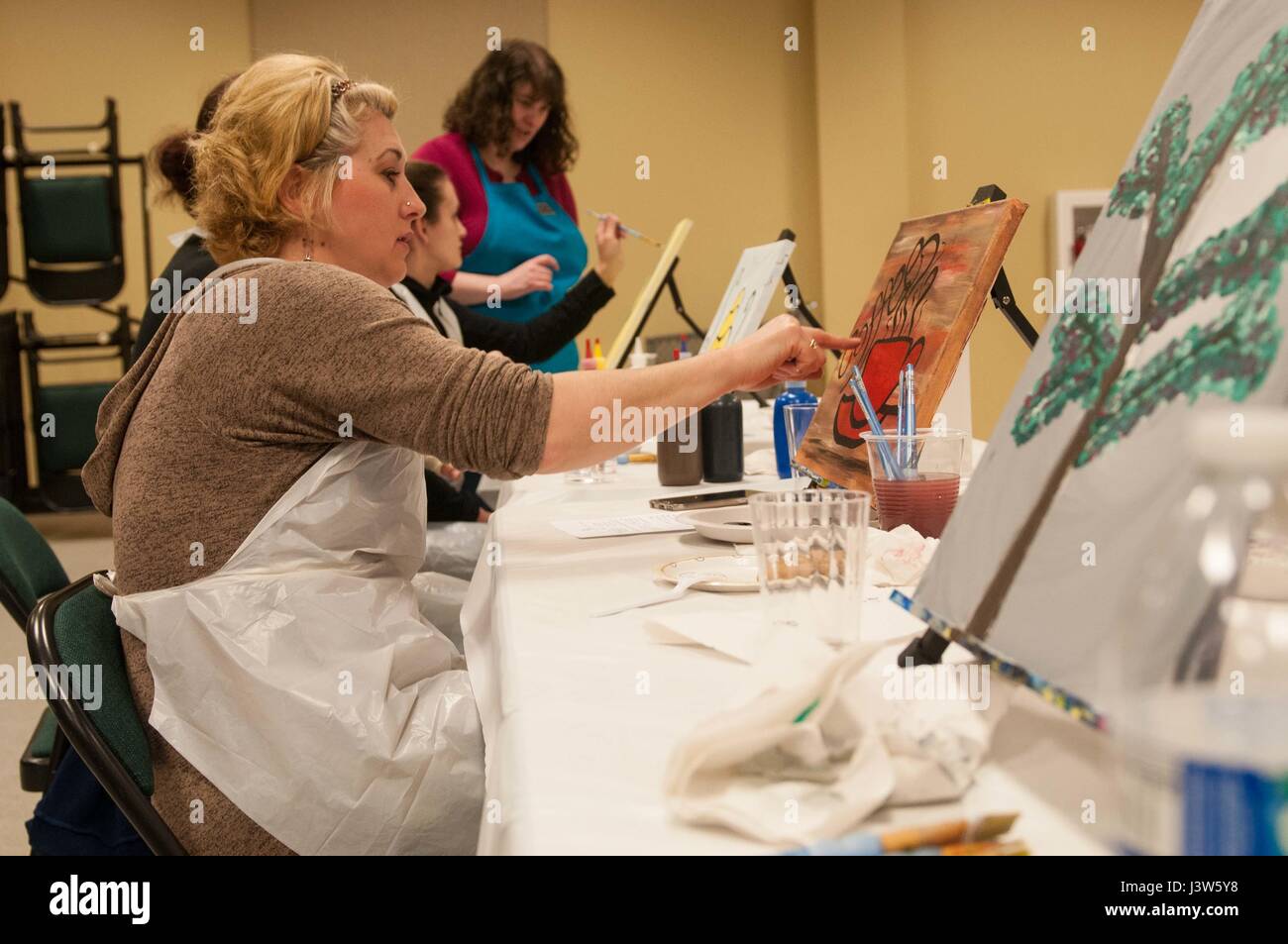 Christine Coles talks about her finish artwork with a friend during a ...