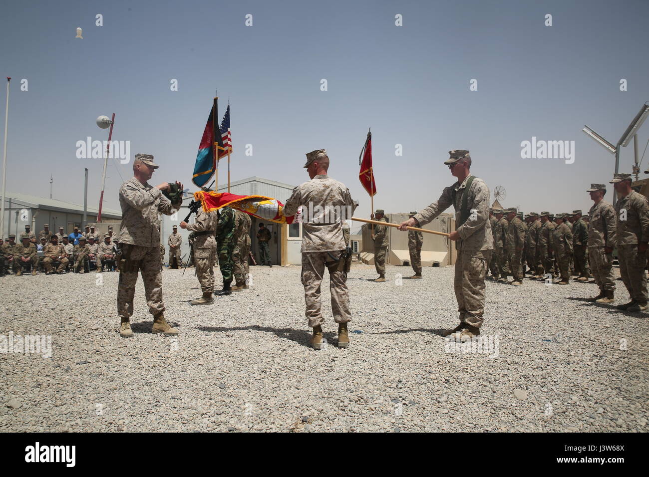 Col. Matthew Reid, left, and Sgt. Maj. Darrell Carver, center, unfurl ...