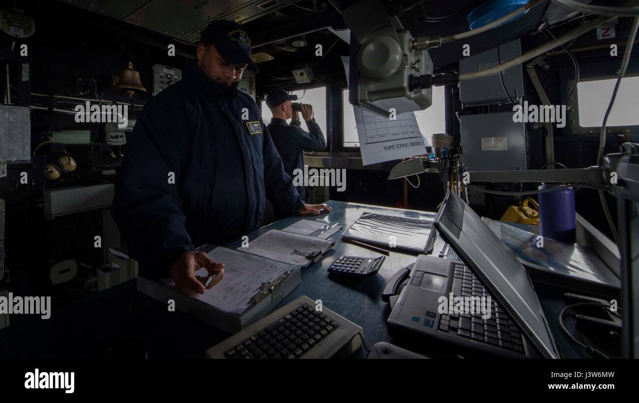 A quartermaster aboard USS Leyte Gulf (CG 55) records deck log ...