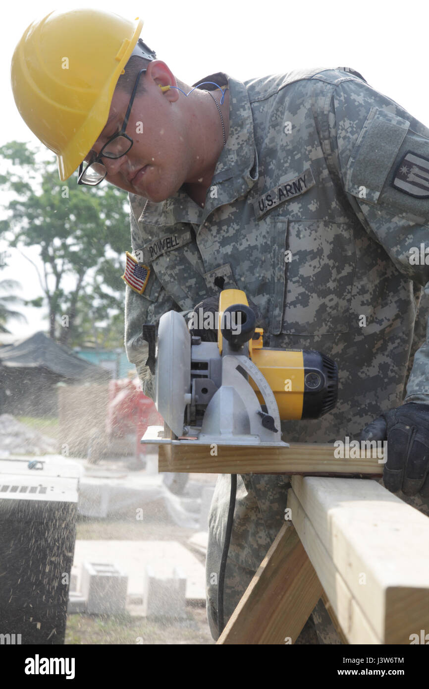 U.S. Army Spc. Sam Powell, with the 372nd Engineer Company, cuts wooden ...