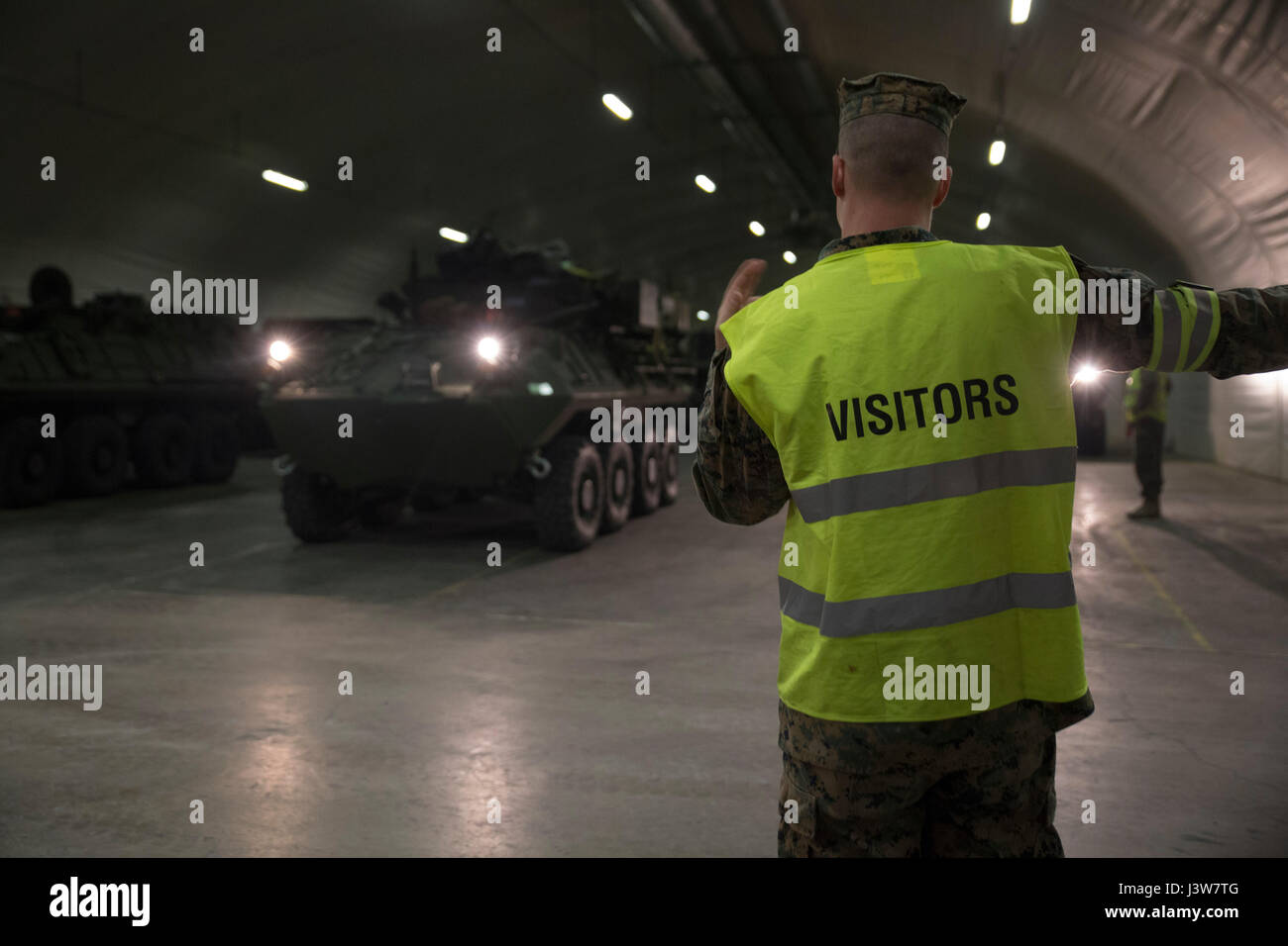 A U.S. Marine with 2nd Transport Support Battalion guides an LAV-25 ...