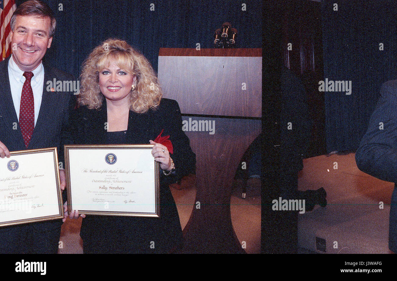 An award recipient is photographed holding their recognition during the ...