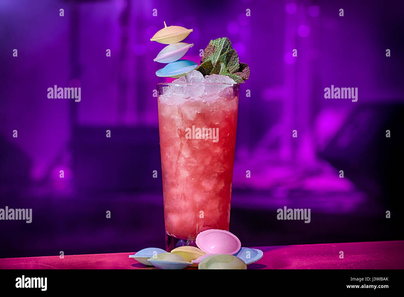 retro red cocktail with space invader sweets with a purple background ...