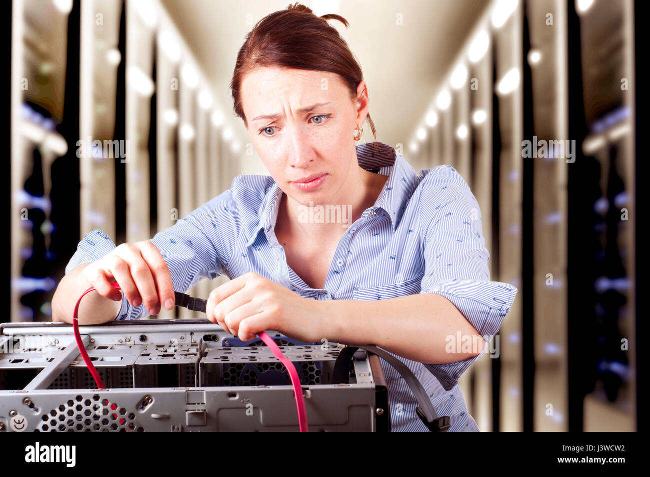 Woman looking confused repairing hardware Stock Photo - Alamy